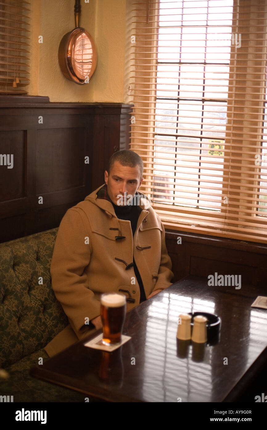 Man in duffle coat alone with pint in Brighton pub, UK Stock Photo - Alamy