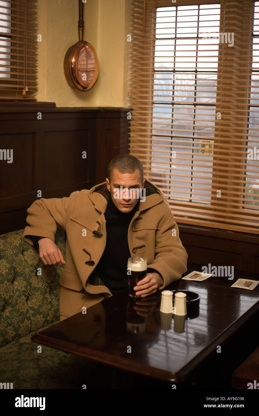 Man in duffle coat alone with pint in Brighton pub, UK Stock Photo - Alamy