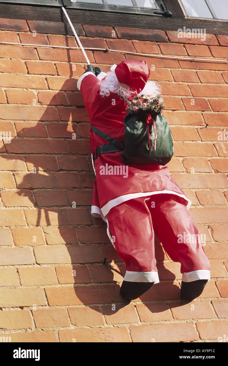 Inflatable santa climbing a rope Stock Photo - Alamy