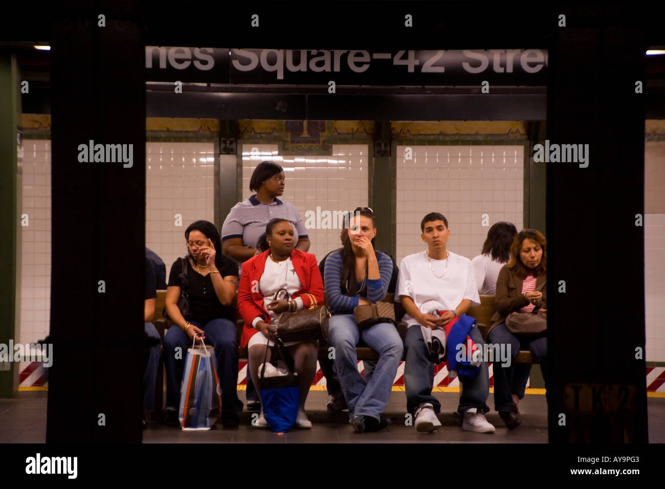 Passengers of different ages and ethnicities wait for a subway train in ...