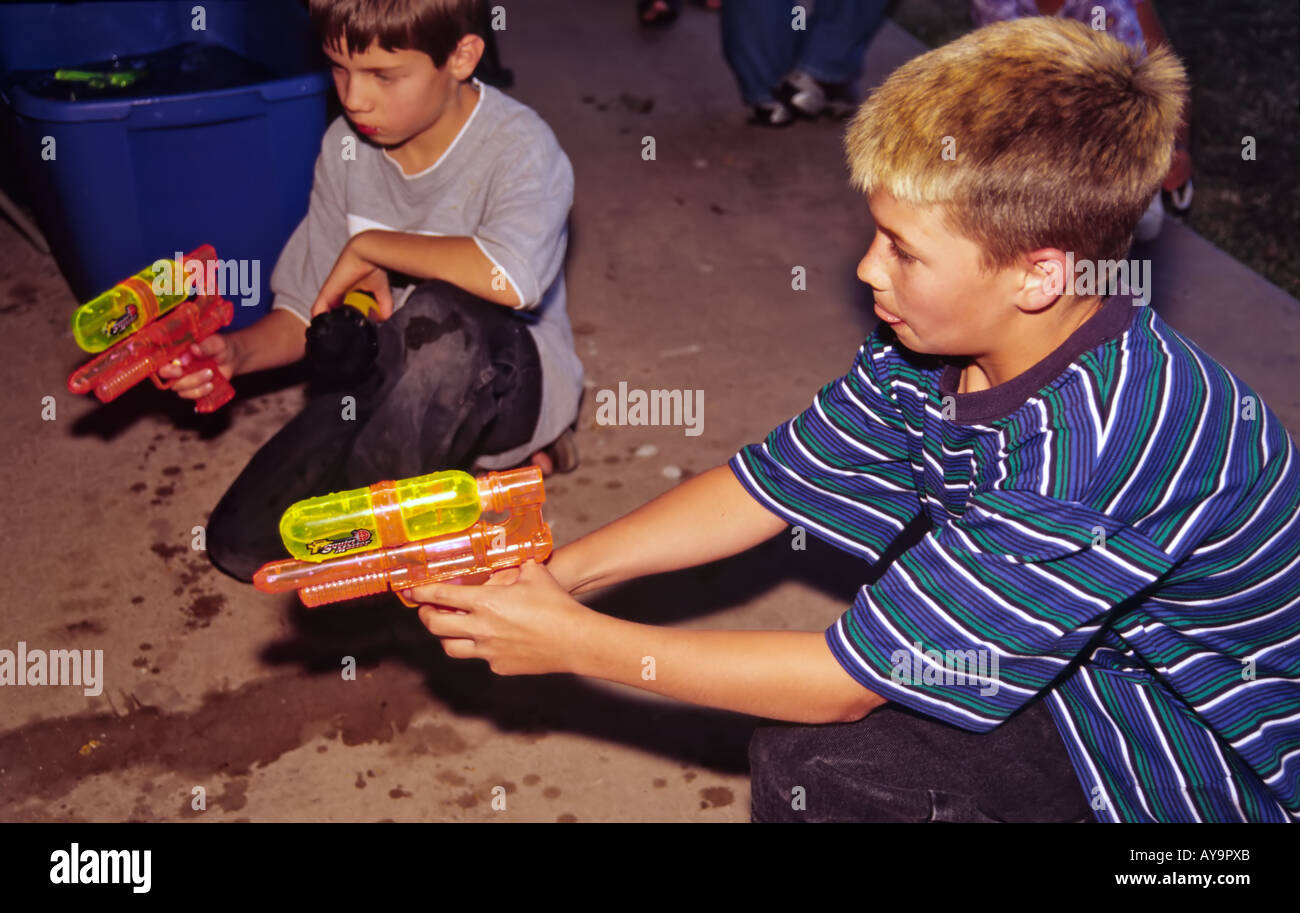 Two boys blast away with water pistols during fiesta, at Saint Francis ...