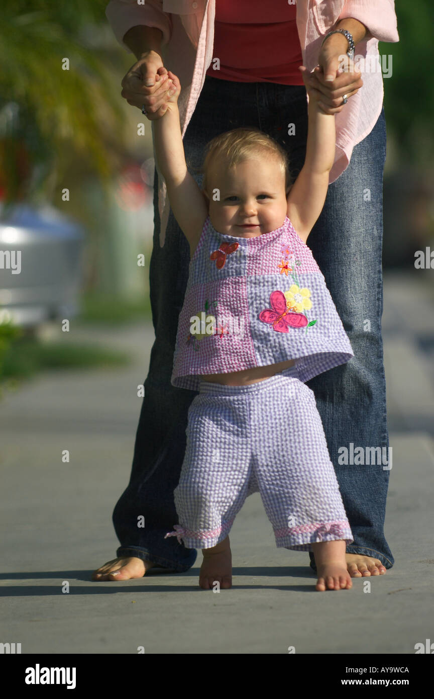 mother helping baby walk Stock Photo - Alamy