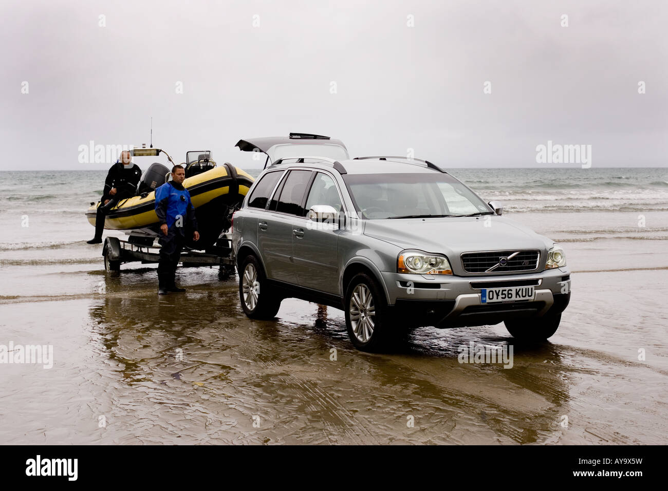 Scuba divers trailing rib boat from sea with 4x4 vehicle Stock Photo ...