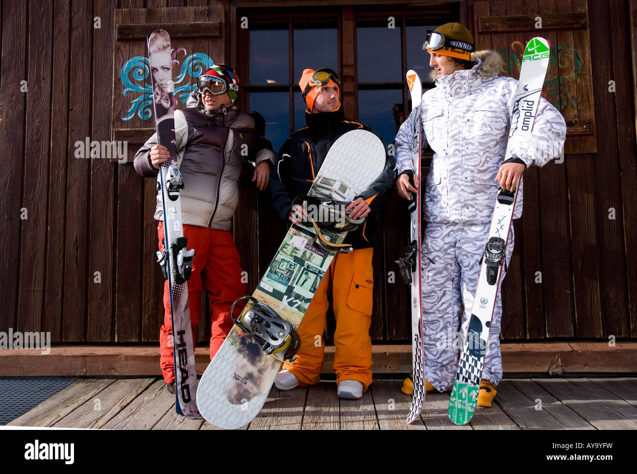 Skiers and snowboarding friends stand in front of window Stock Photo ...