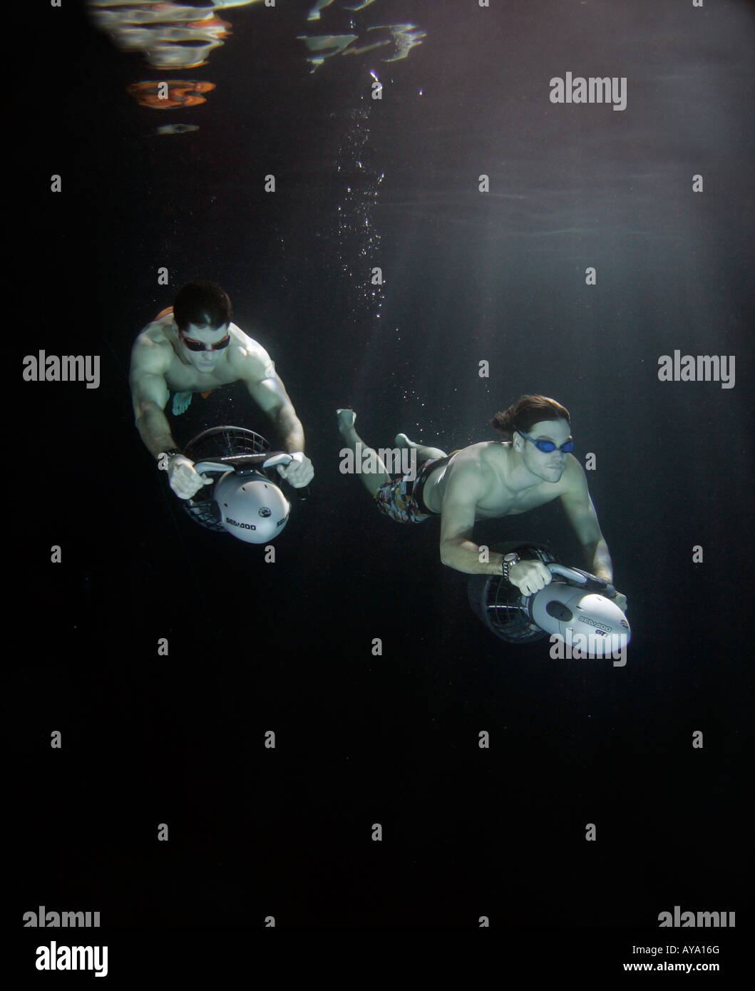 Two men diving with underwater scooters Stock Photo - Alamy