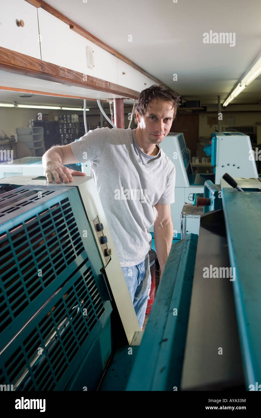 Portrait of a blue-collar man standing behind a printing machine Stock ...