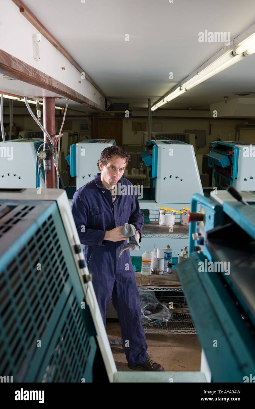 Portrait of a man in coveralls behind a printing machine Stock Photo ...