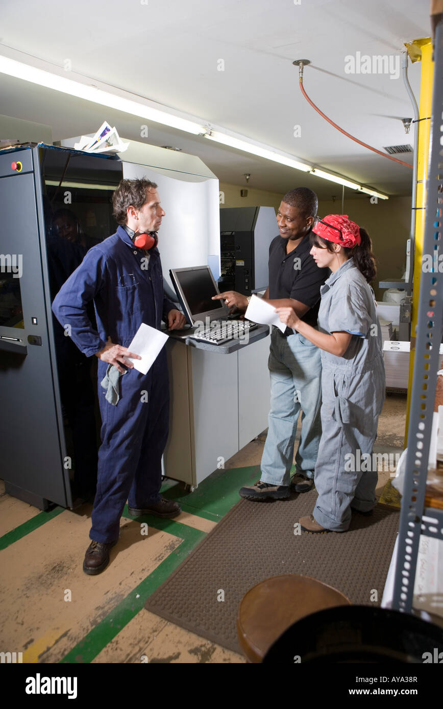 Workers being trained to use a piece of machinery with computer ...