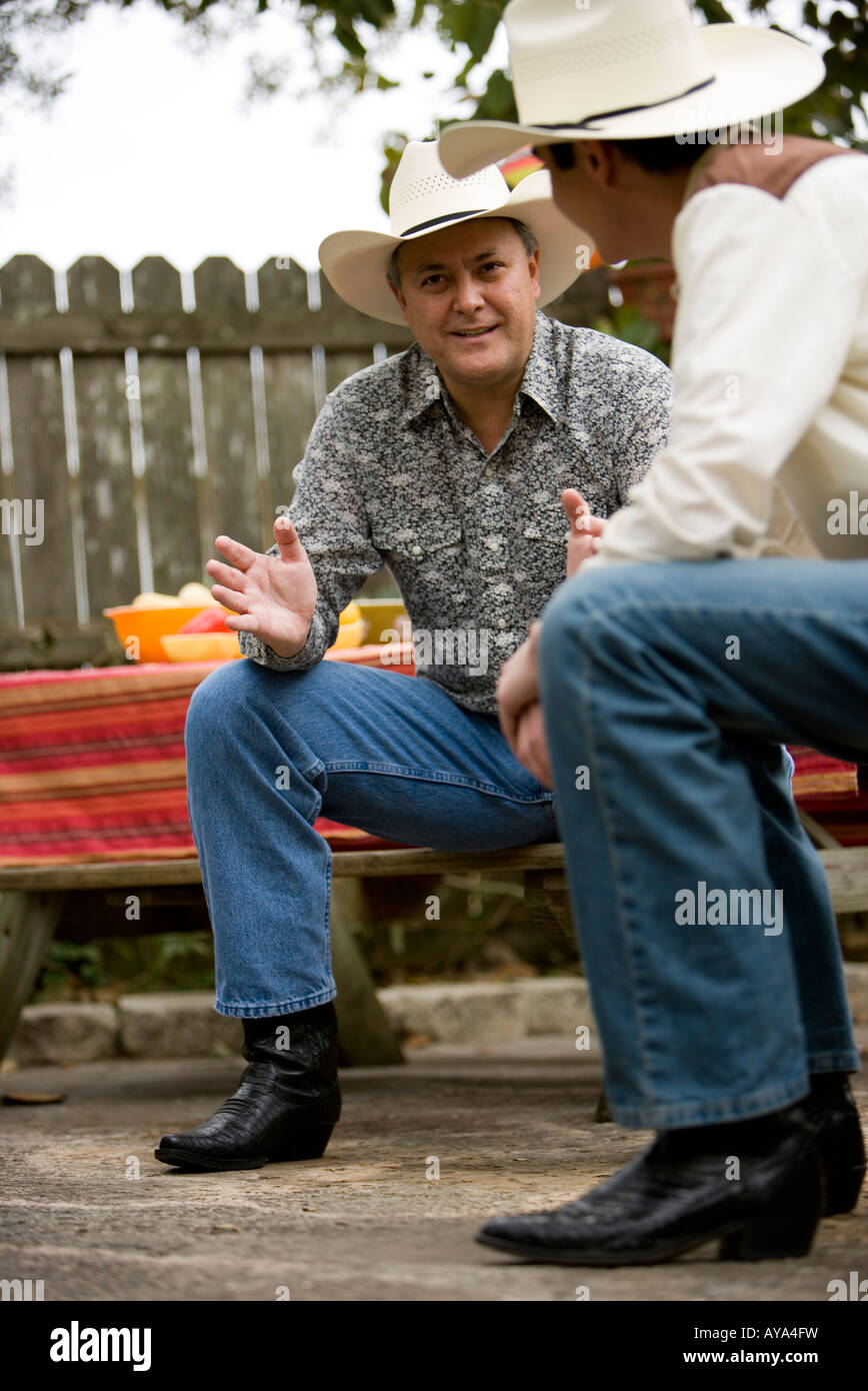 Tex-Mex father and son in backyard conversing Stock Photo - Alamy