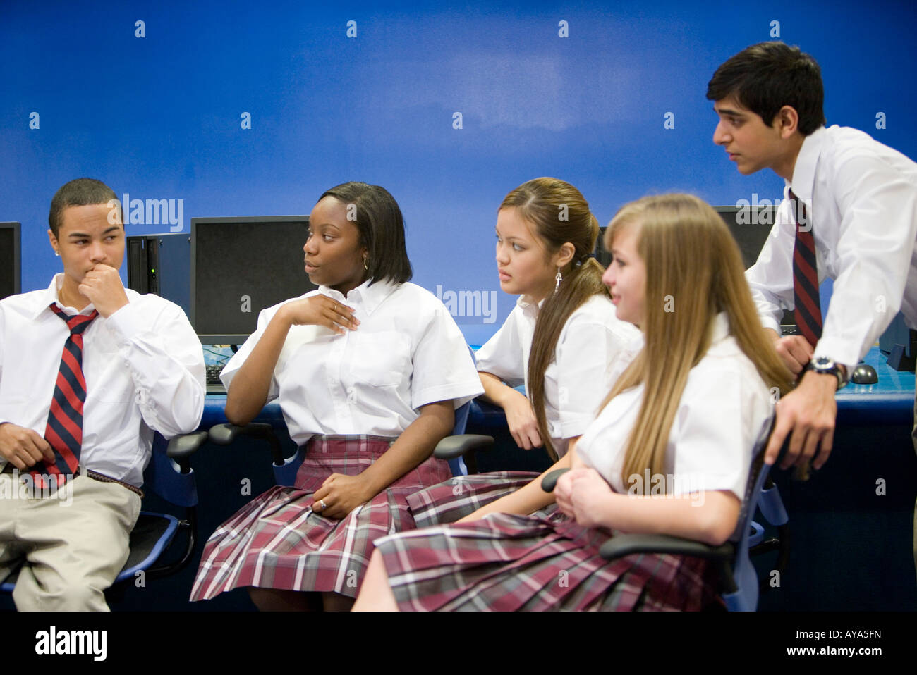 Group of high school classmates sitting together conversing Stock Photo ...
