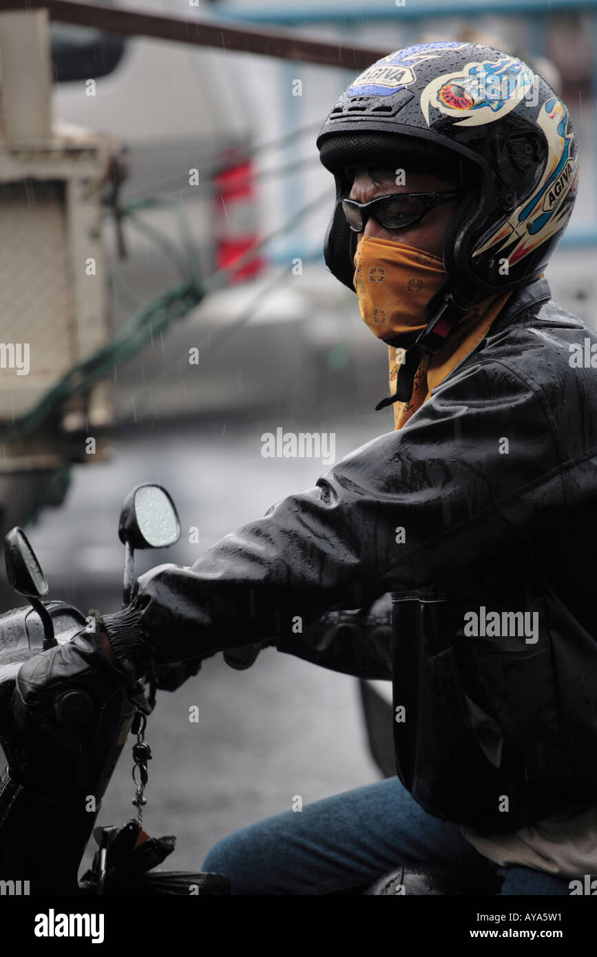 Indonesia Jakarta Portrait of man riding motor scooter in middle of ...