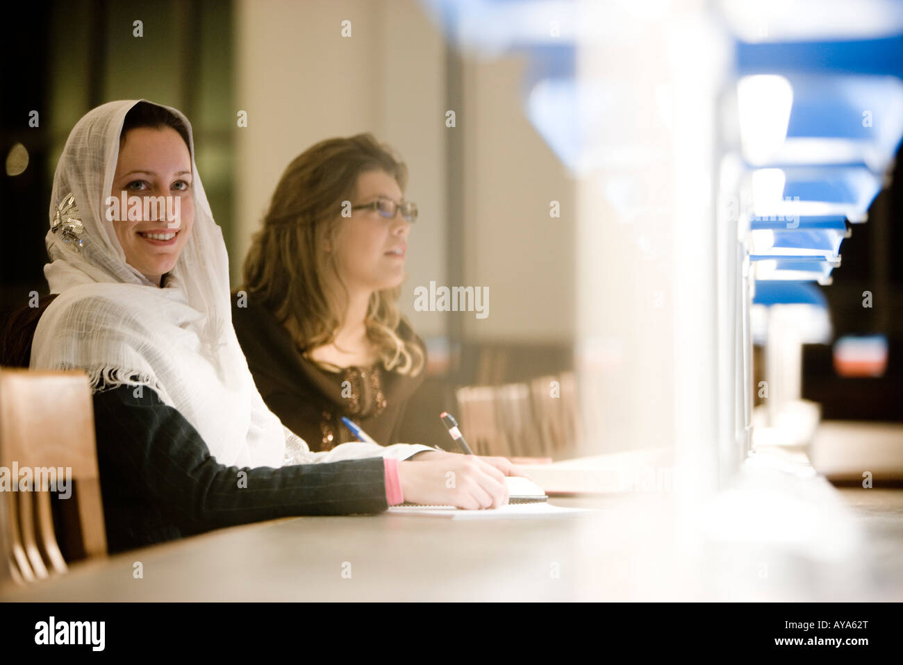 Two young women sitting in the reading room of a library Stock Photo ...