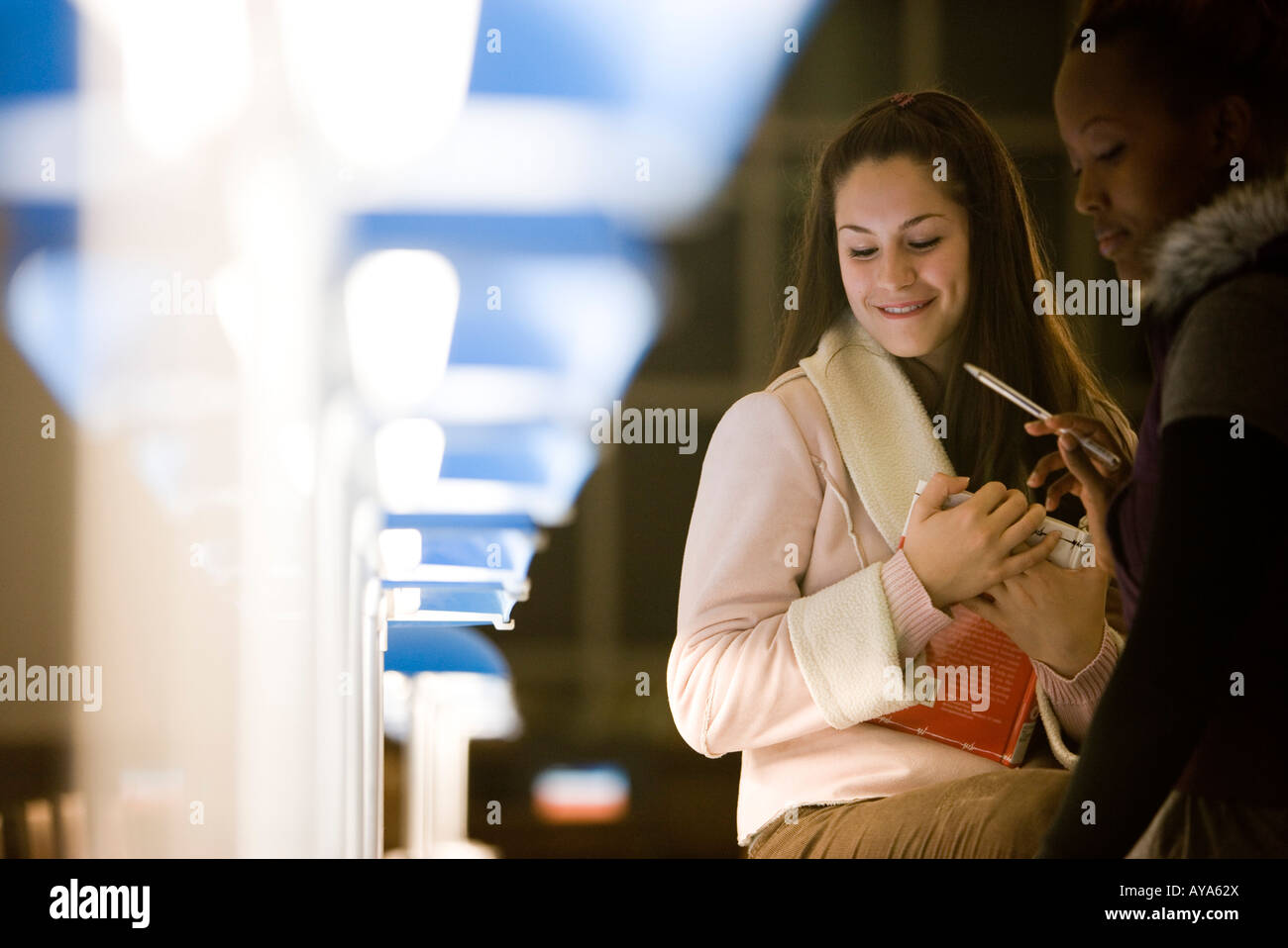 Two young women sitting in the reading room of a library Stock Photo ...