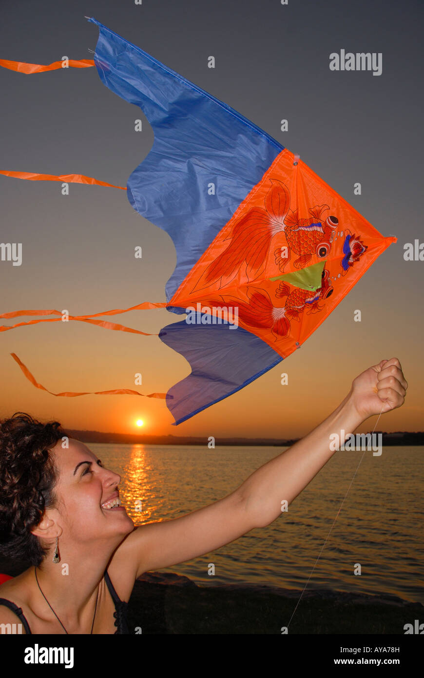 YOUNG FEMALE FLYING KITE IN FULL OF JOY Stock Photo - Alamy