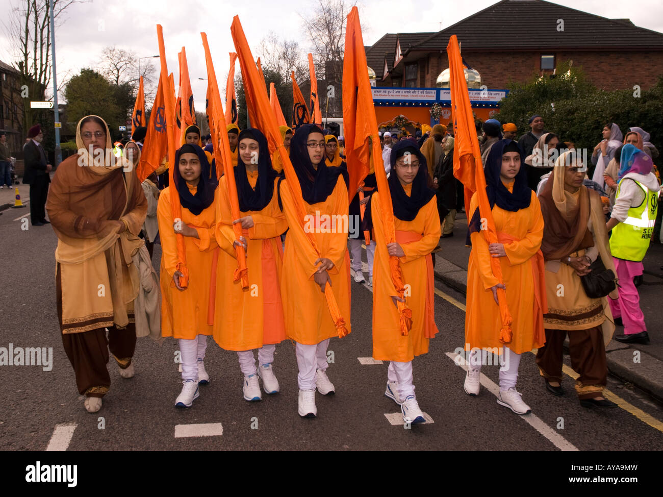 Sikh women carrying Sikh flag during procession for Vaisakhi Hounslow ...