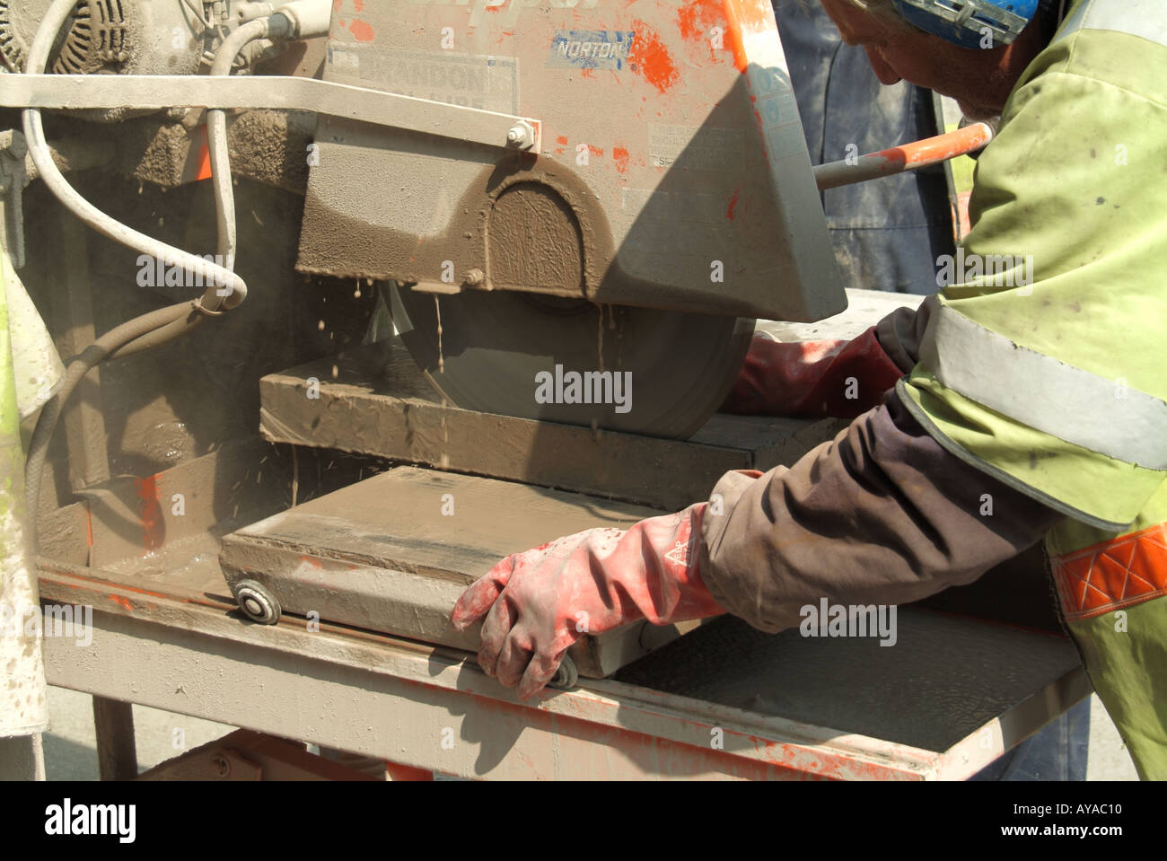 Close up of workman using a powered high speed circular cutting disc to ...