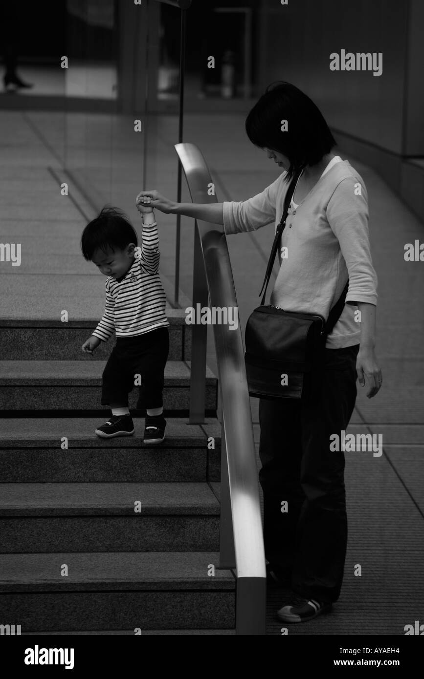 Asia Tokyo Japan Mother and young child on stairs in Shinkuku District ...