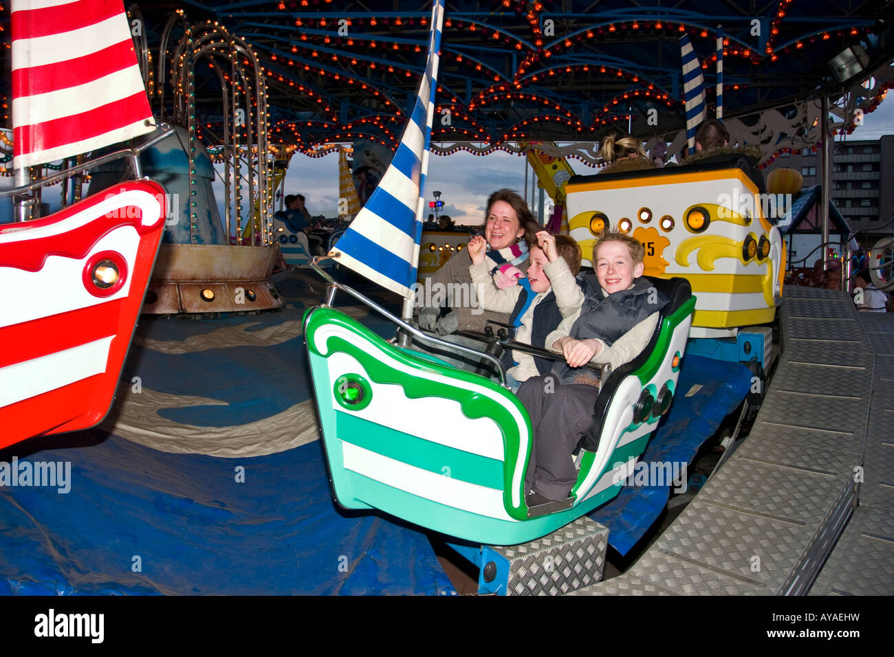 Mum and two young children on fairground ride Stock Photo - Alamy