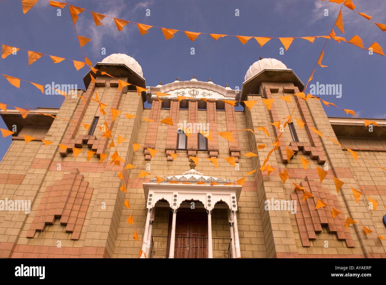 Facade of Sikh temple or Gurdwara adorned with flags for the festival ...