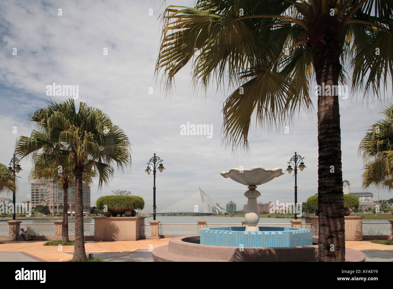 Malaysia Kuala Lumpur Palm trees and gardens along artificial lake ...