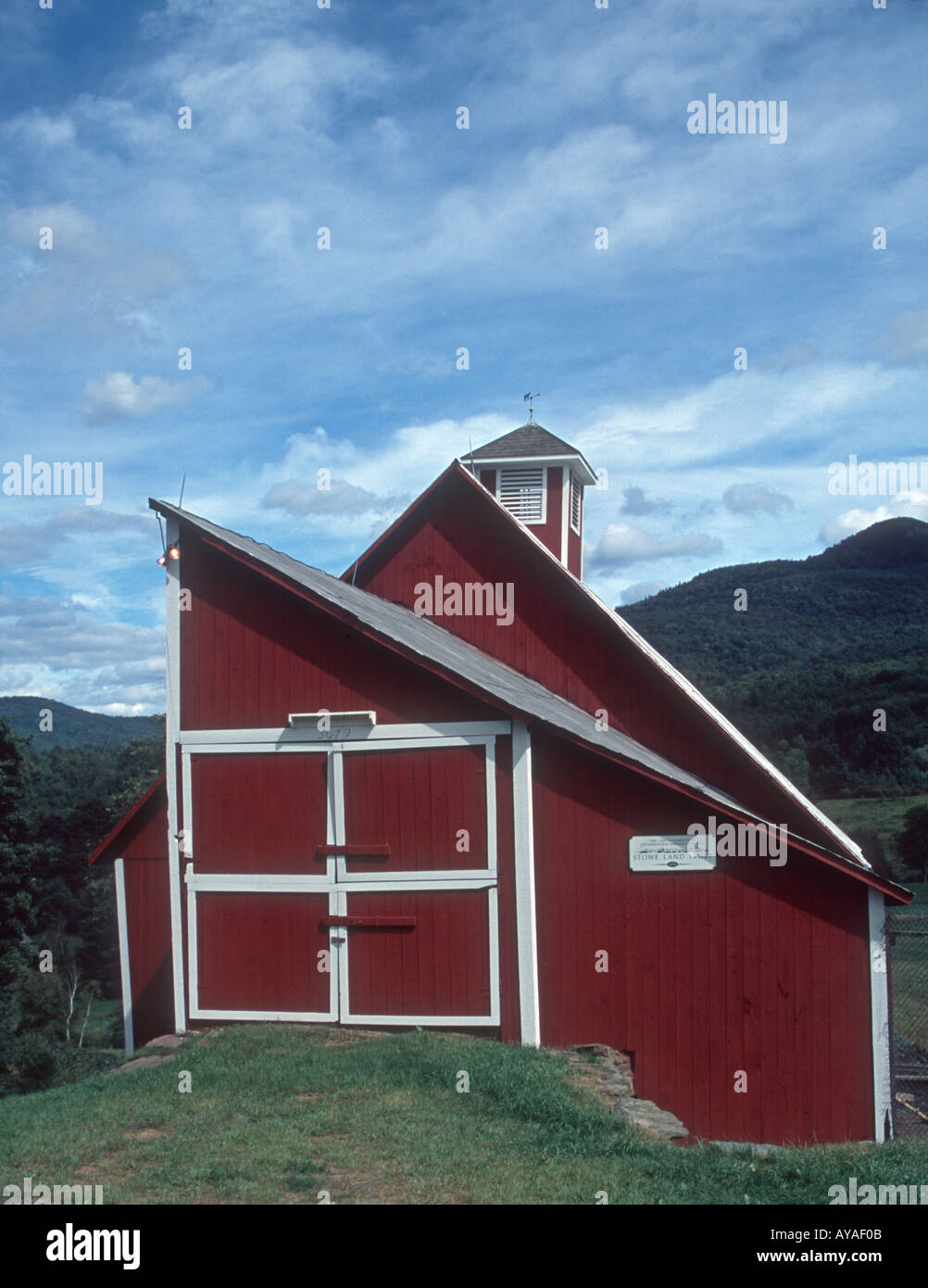 Red barn with white trim against blue sky with clouds Stowe Vermont ...