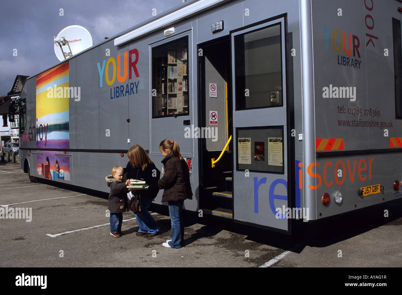 A Young Family With Books From A Mobile Library Stock Photo - Alamy