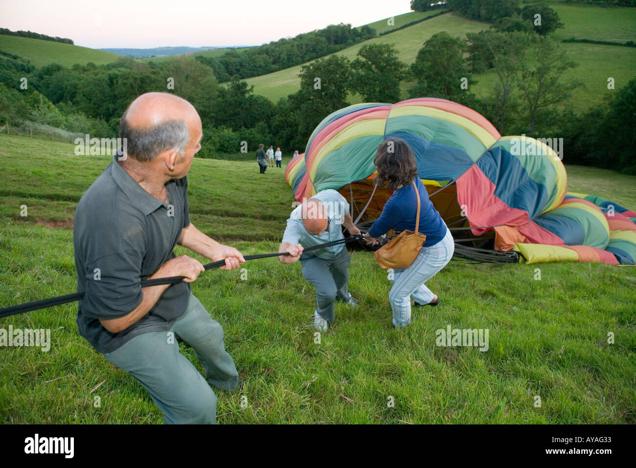 People holding a tether rope as a hot air baloon deflates Stock Photo ...