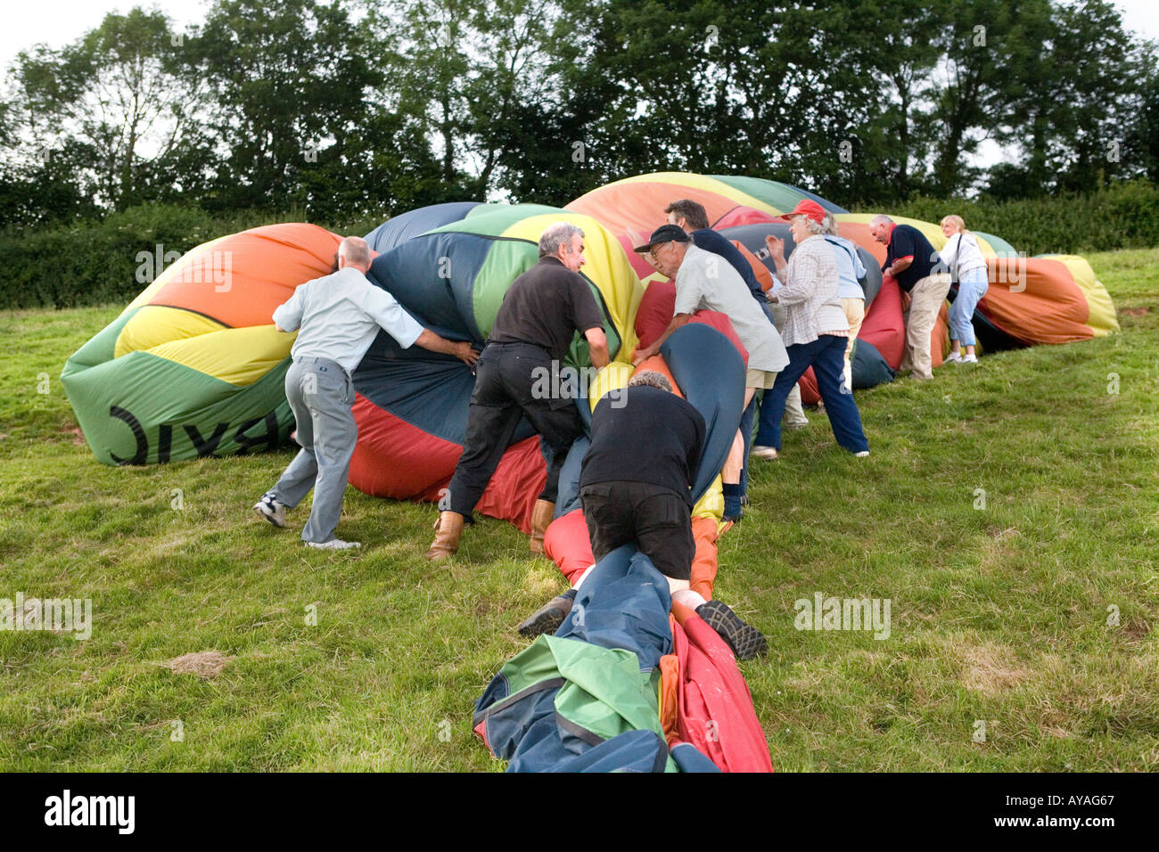 People helping to put roll up a hot air balloon after a flight Stock ...