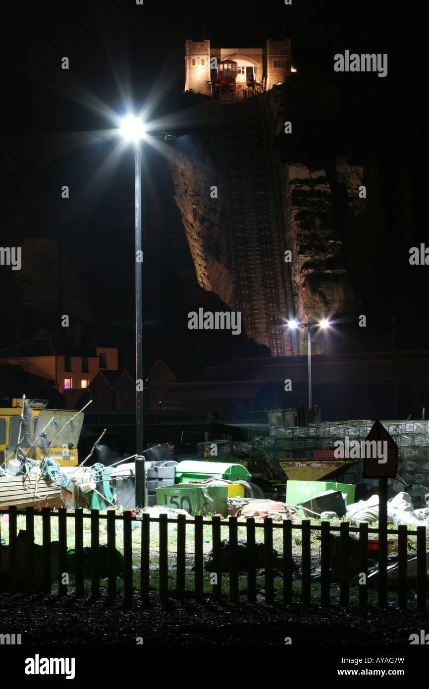 Night time on a working beach with vertical tram in background ...