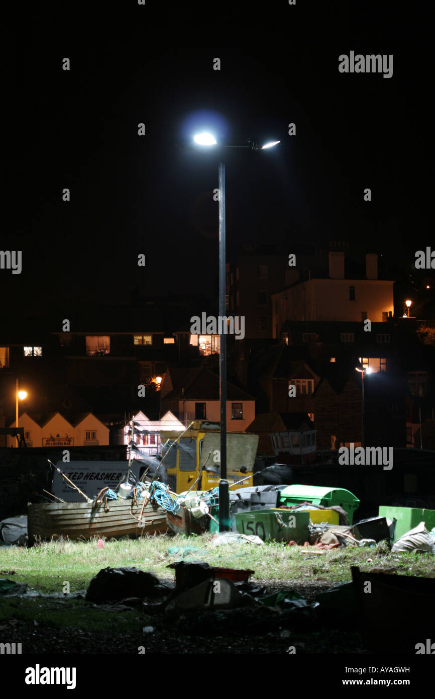 Night time on a working beach with vertical tram in background ...