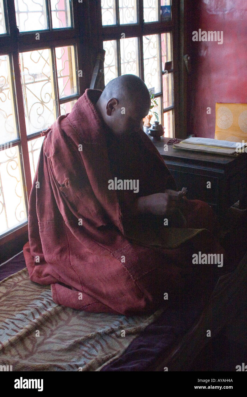 Tibetan monk meditating by a window in the Drepung Monastary in Tibet ...