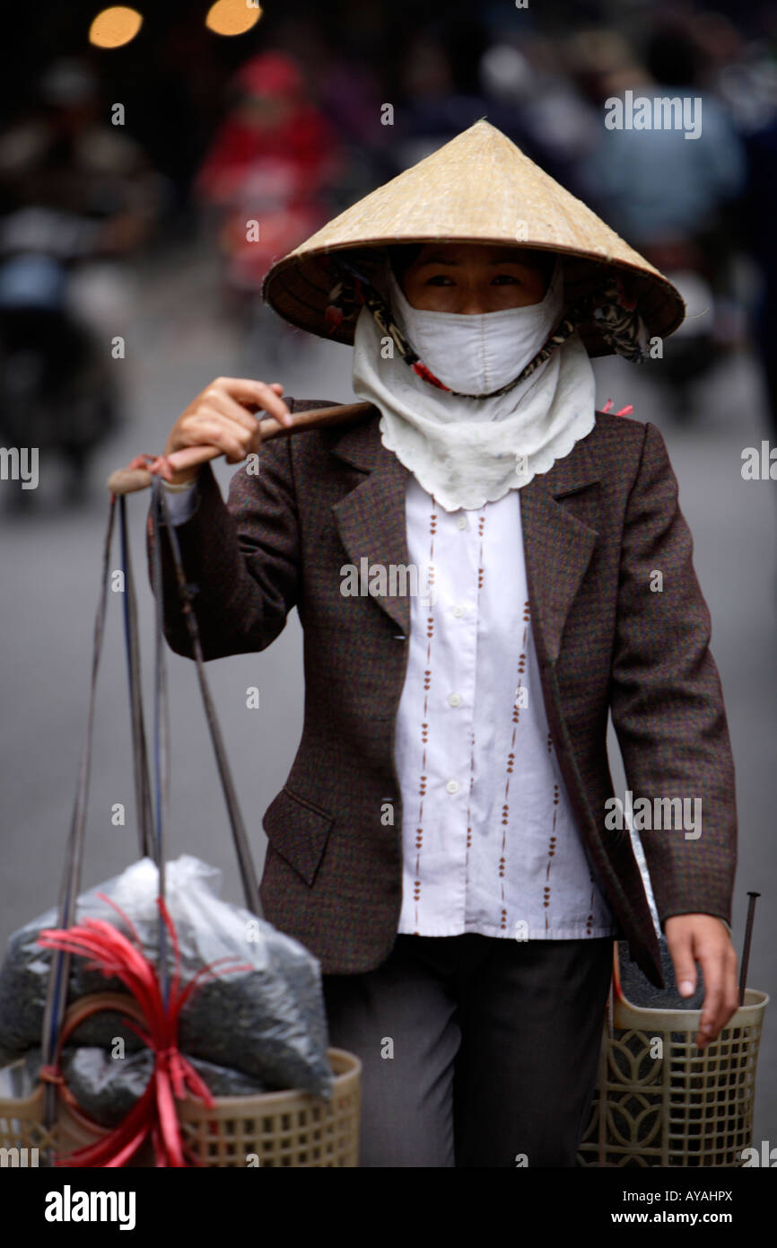 Woman carrying a traditional Vietnamese ‘don ganh’ yoke, Old Quarter ...