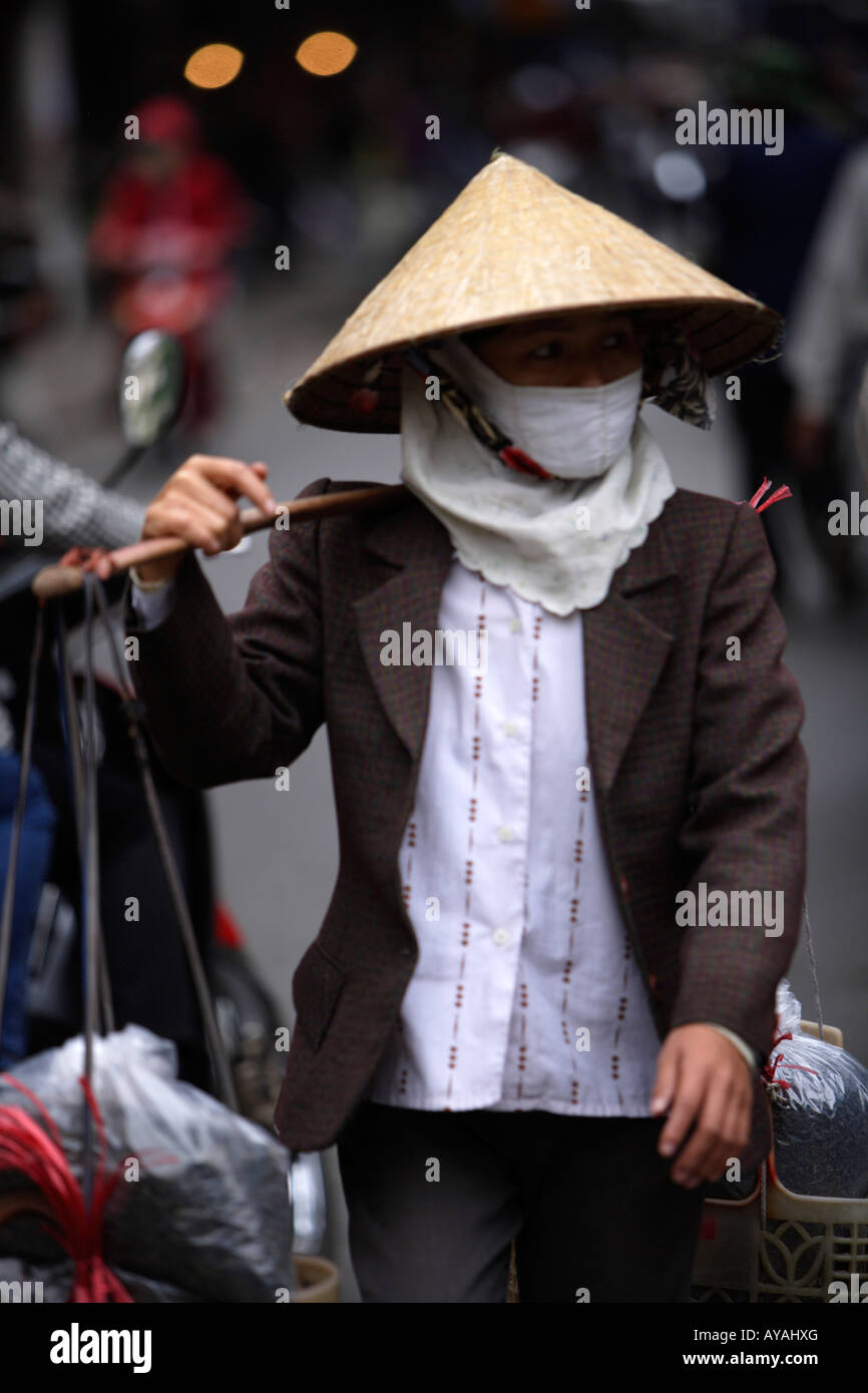 Woman carrying a traditional Vietnamese ‘don ganh’ yoke, Old Quarter ...
