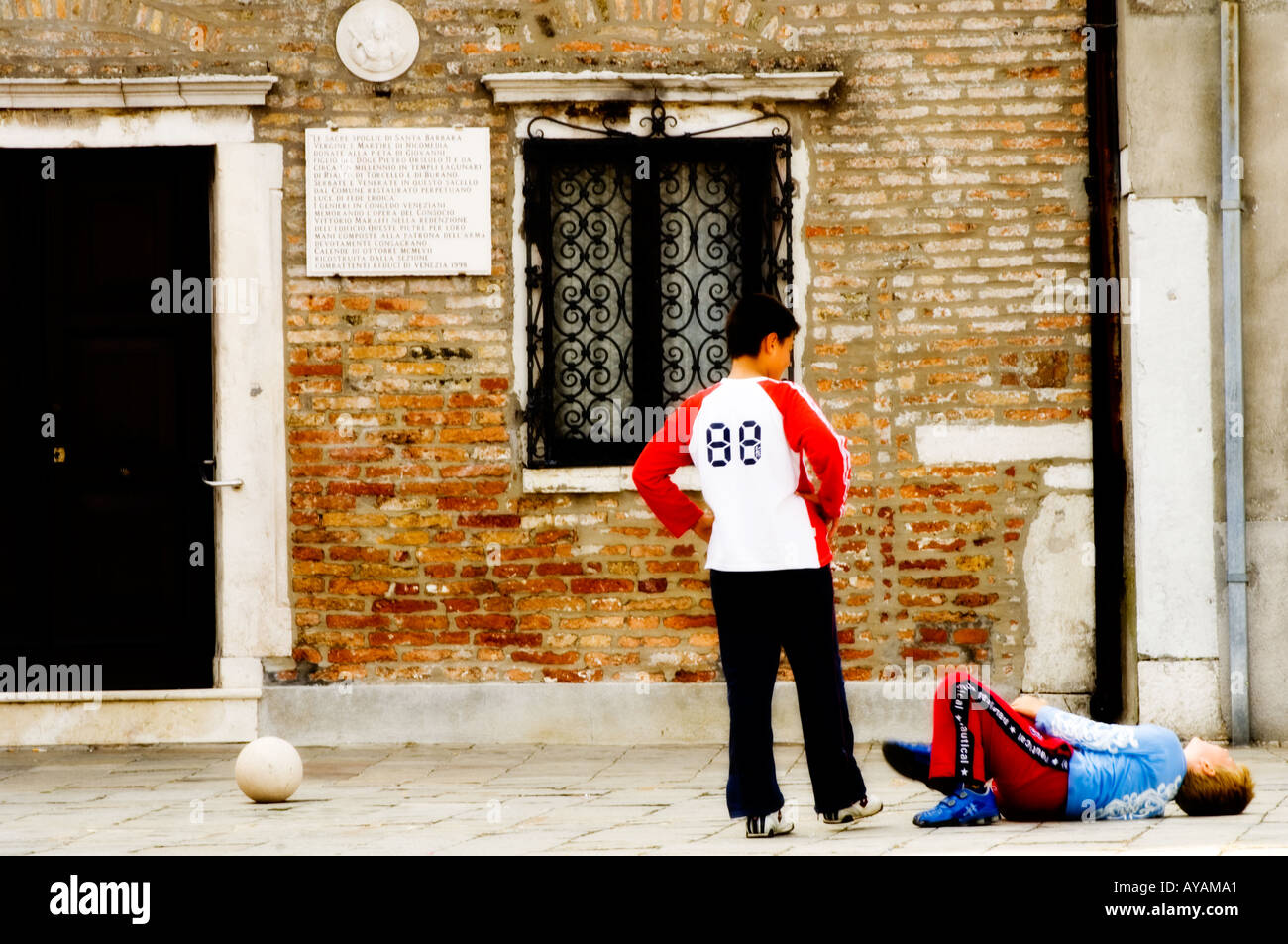 two boys playing soccer suffer a setback when one is hit by ball Stock ...