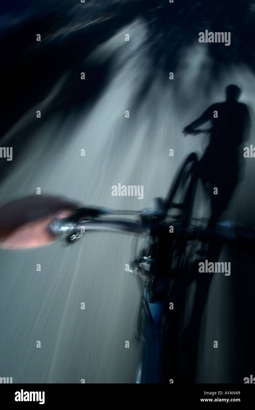 long exposure of cyclist's shadow as bike races down street Stock Photo ...