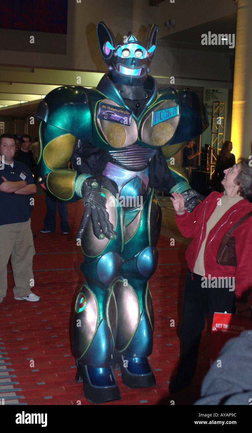 A large robot reaches out to a woman walking at the Auto show in ...