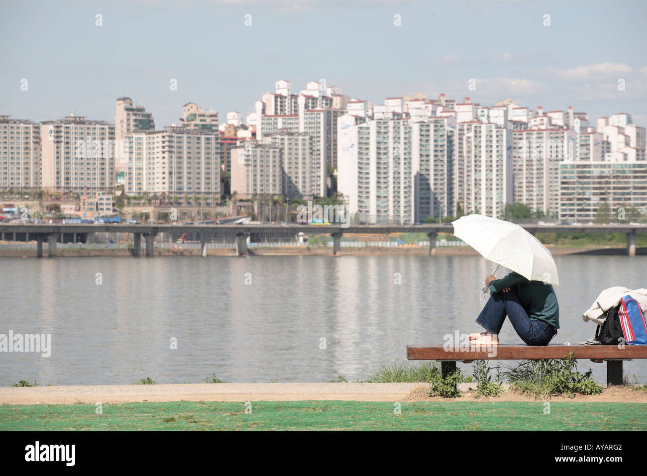 South Korea Seoul Woman sitting on bench along Hangang River Park Stock ...