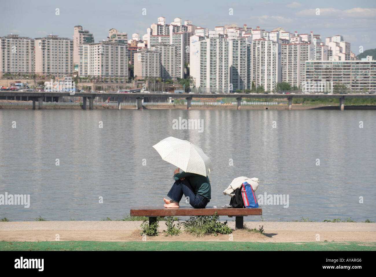 South Korea Seoul Woman sitting on bench along Hangang River Park Stock ...