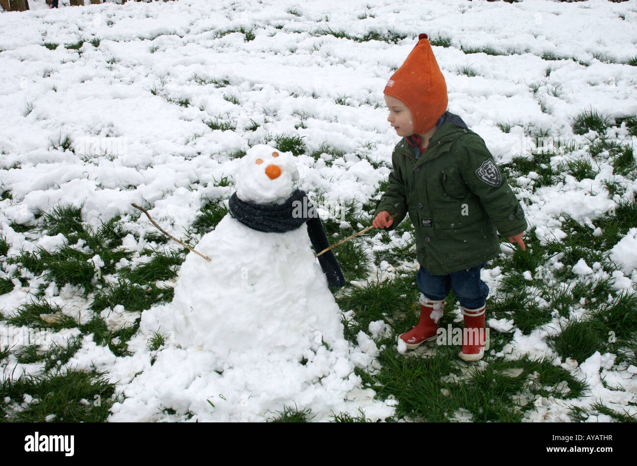 A young boy holding hands with a snowman Stock Photo - Alamy