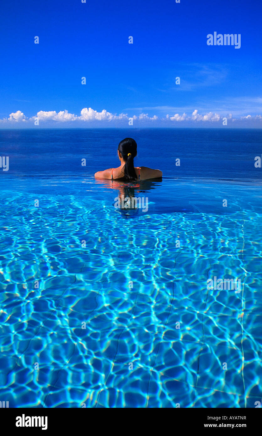 Woman in swimming pool overlooking ocean, Bali, Indonesia Stock Photo ...