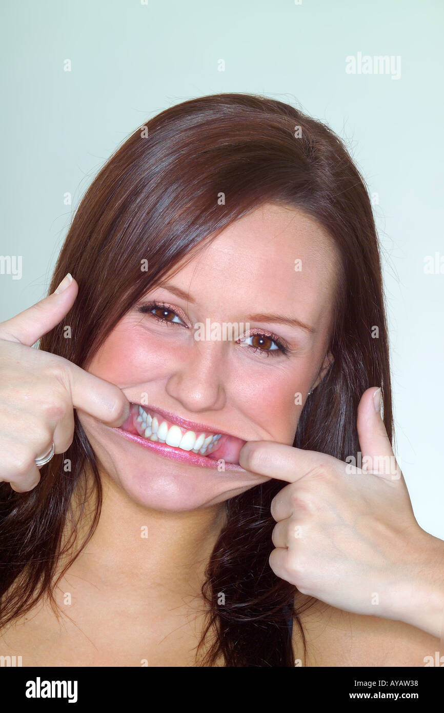 Portrait of young woman pulling funny face Stock Photo - Alamy