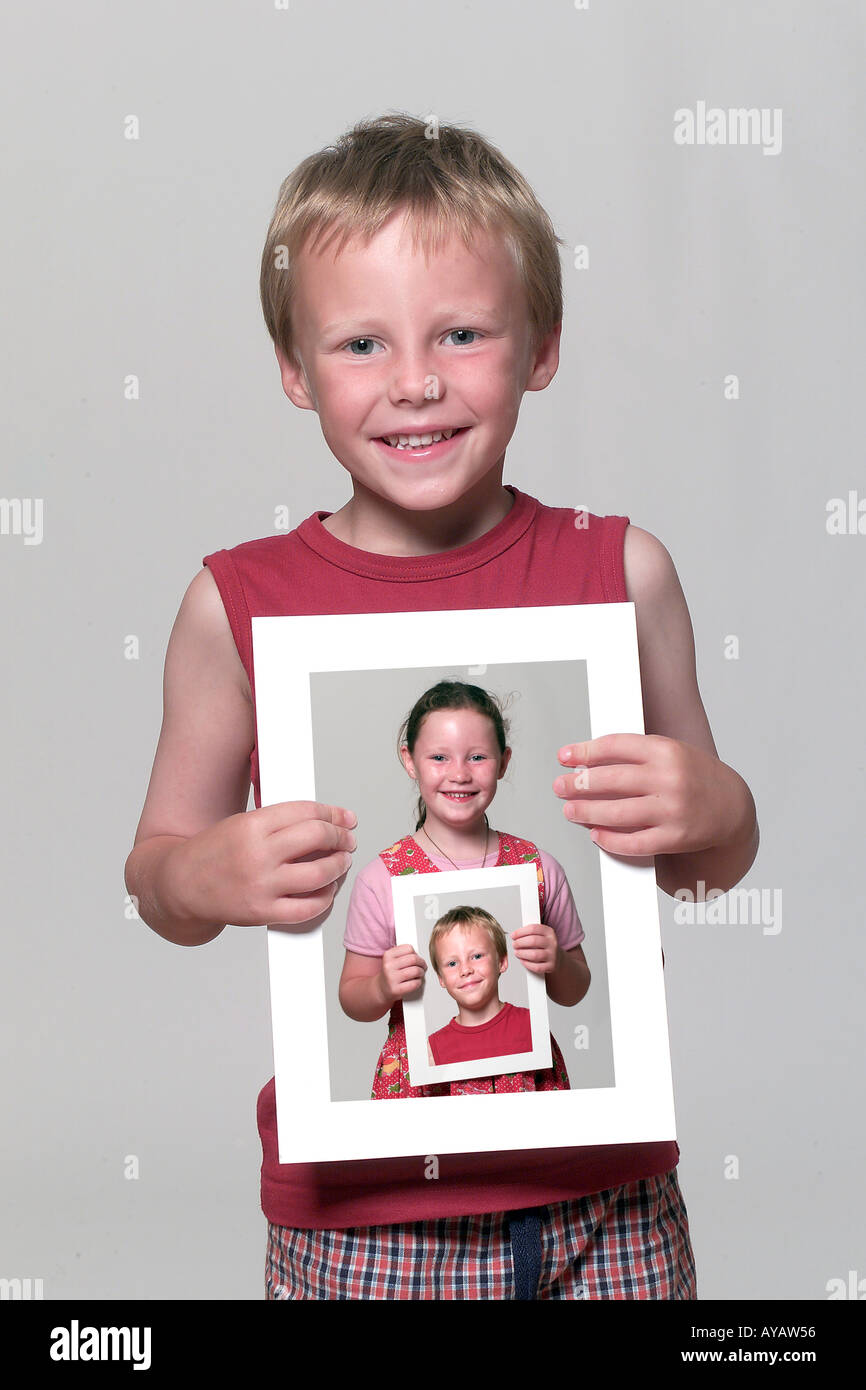 Boy holding picture of girl holding picture of boy, portrait Stock ...