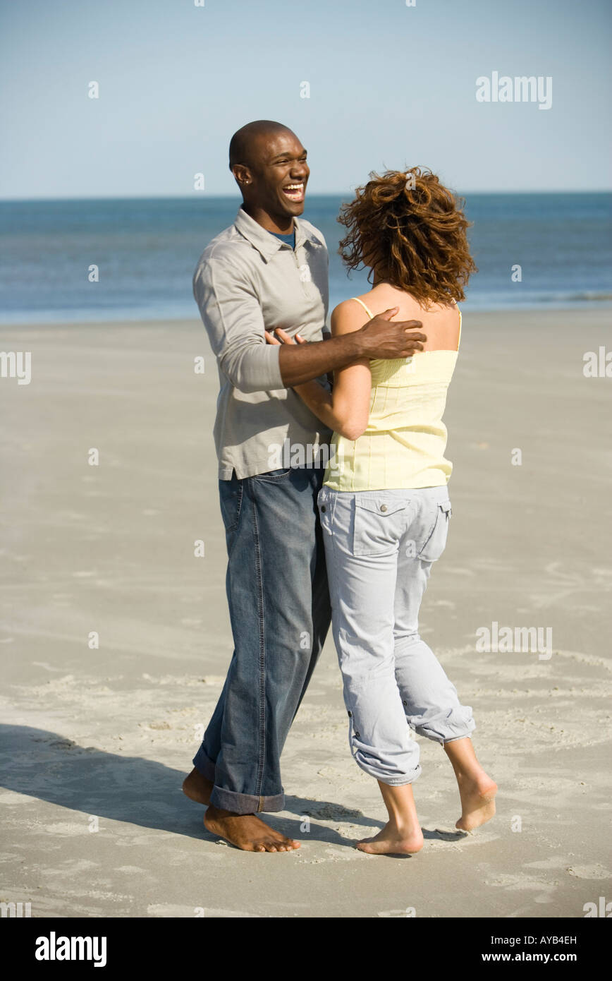 View of a young couple embracing and frolicking on beach Stock Photo ...