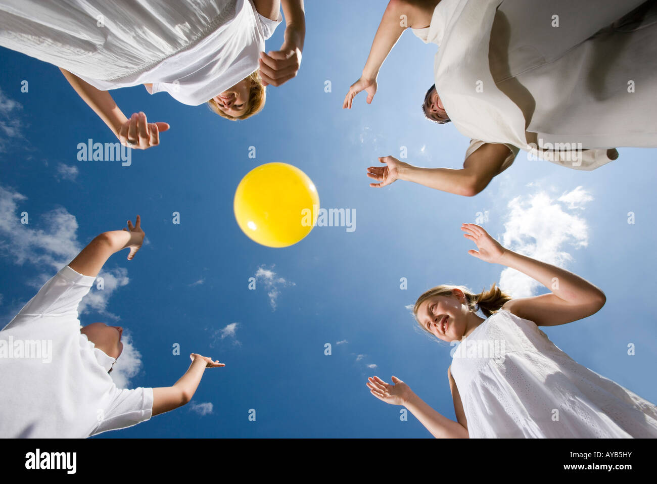 Children playing yellow ball together hi-res stock photography and ...