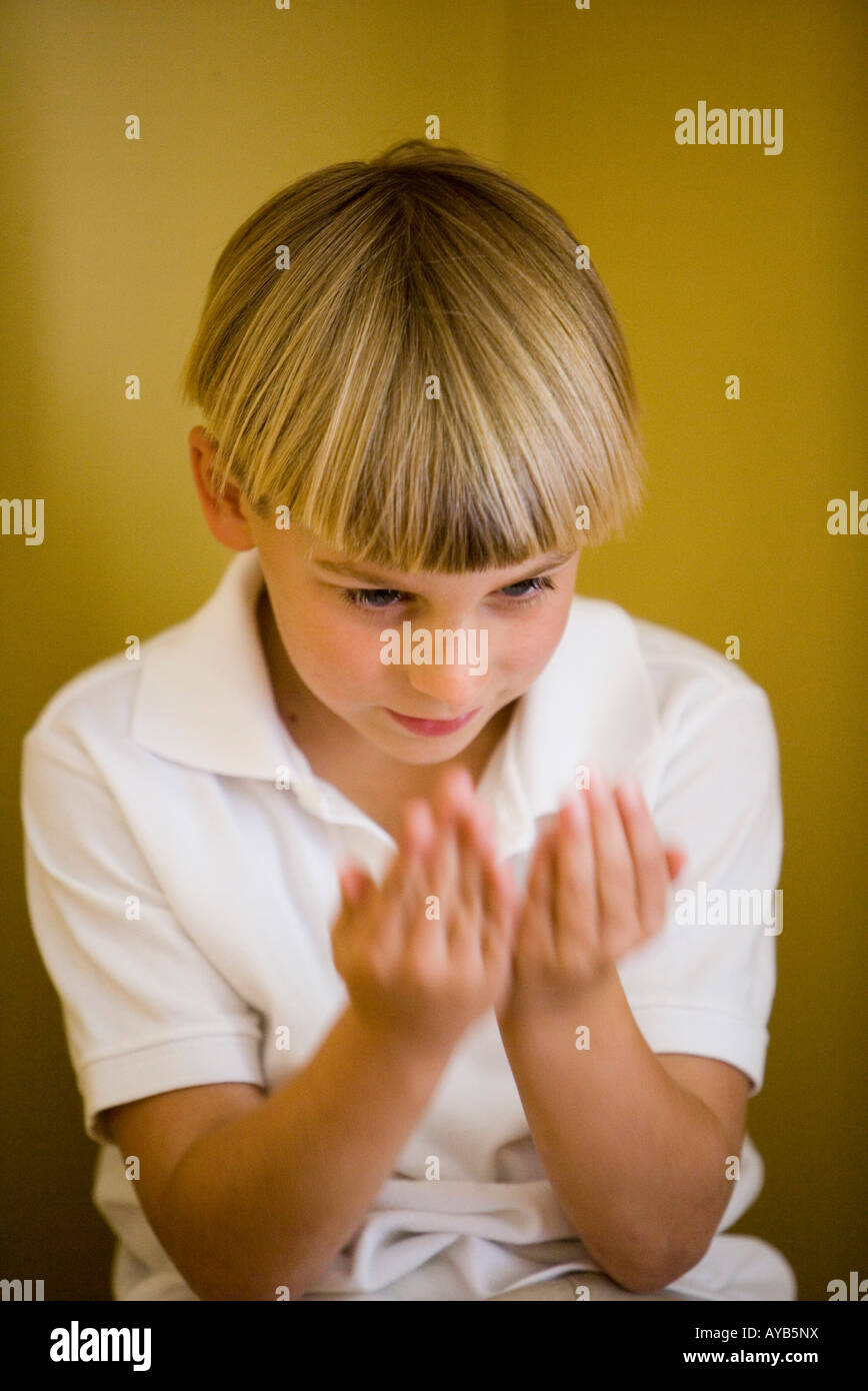Boy staring at hands Stock Photo - Alamy