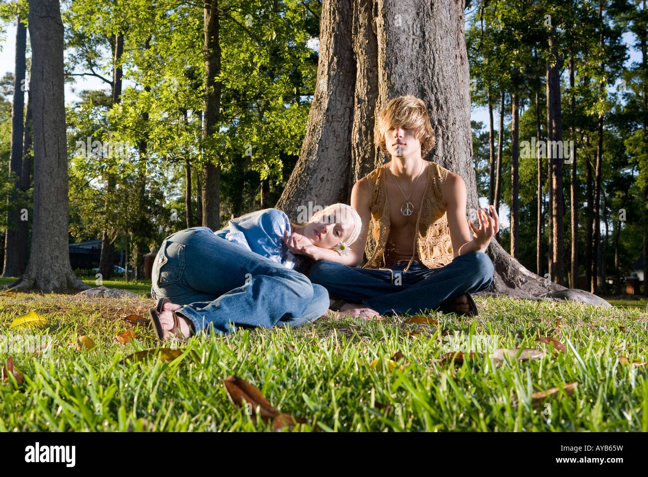 Young hippie couple relaxing and meditating under tree Stock Photo - Alamy