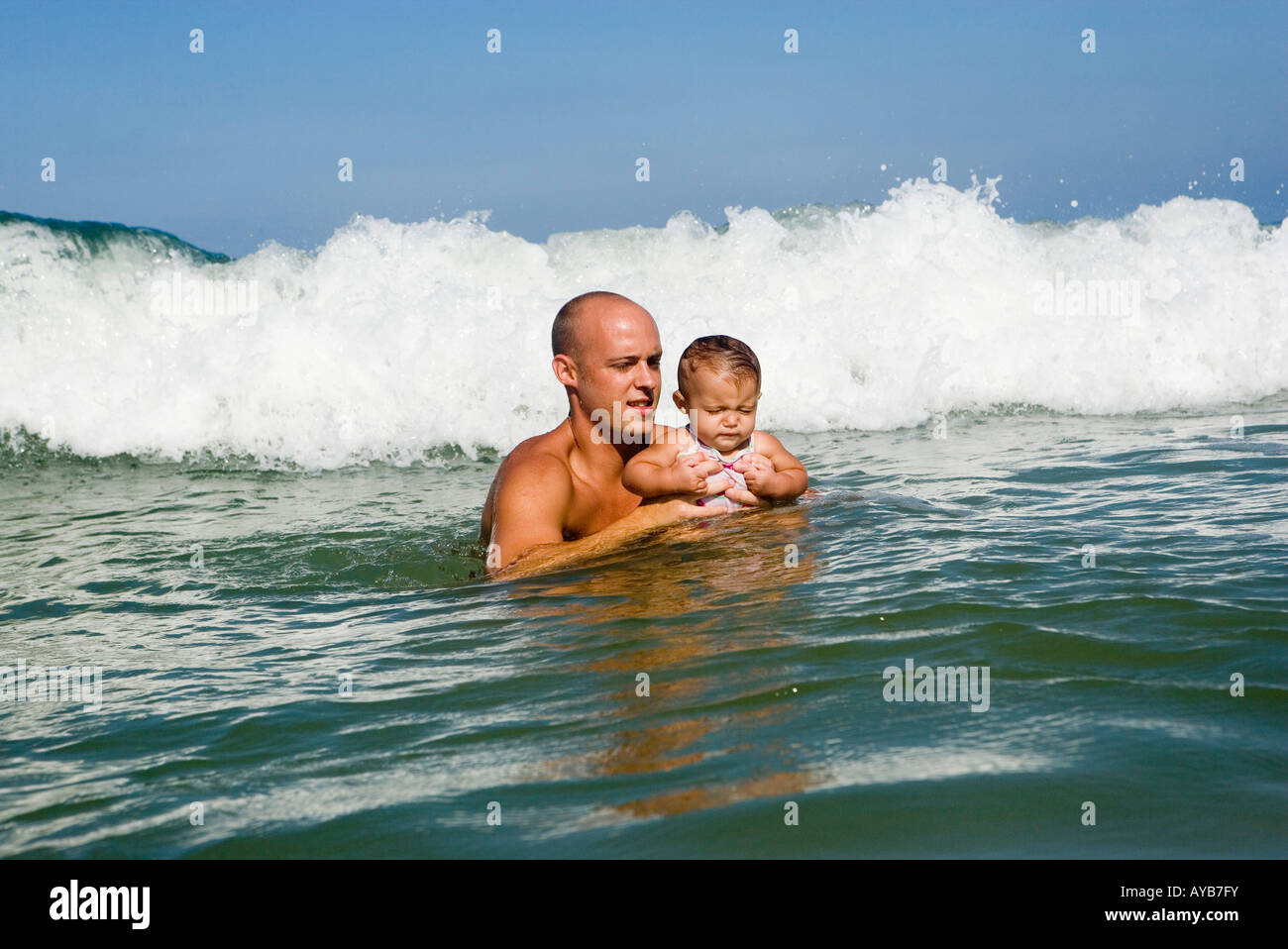 Father playing with baby girl in the ocean waves Stock Photo - Alamy