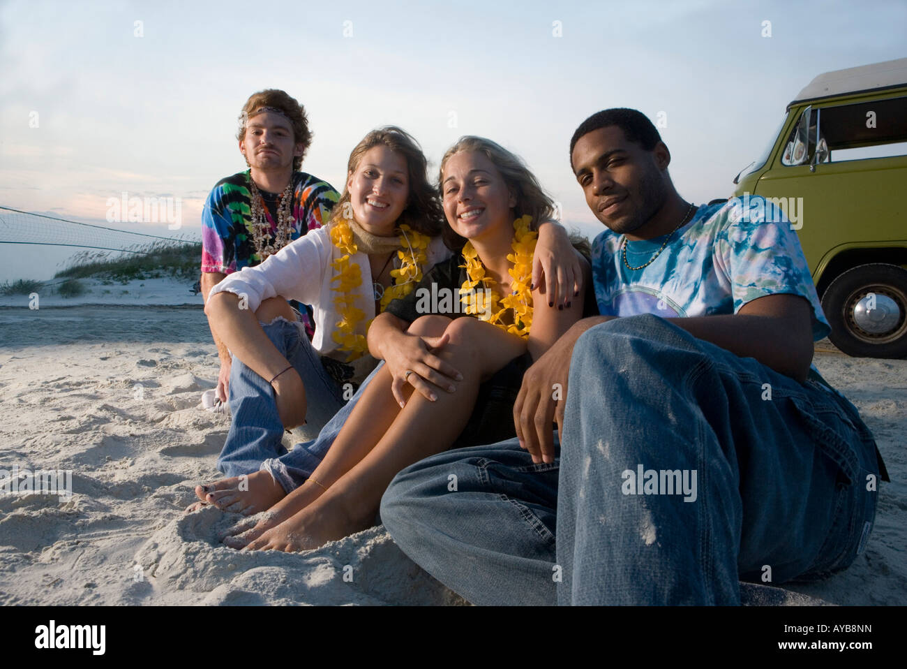 Hippies sitting on sand at beach at dusk Stock Photo - Alamy