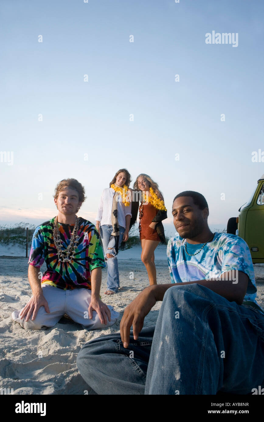 Hippies sitting on sand at beach at dusk Stock Photo - Alamy