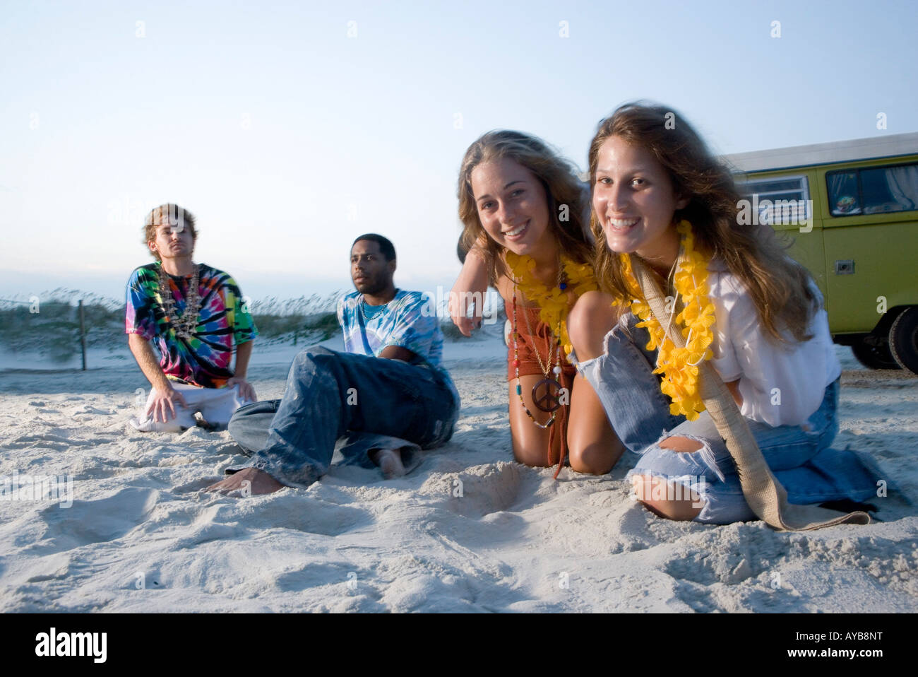 Hippies sitting on sand at beach at dusk Stock Photo - Alamy